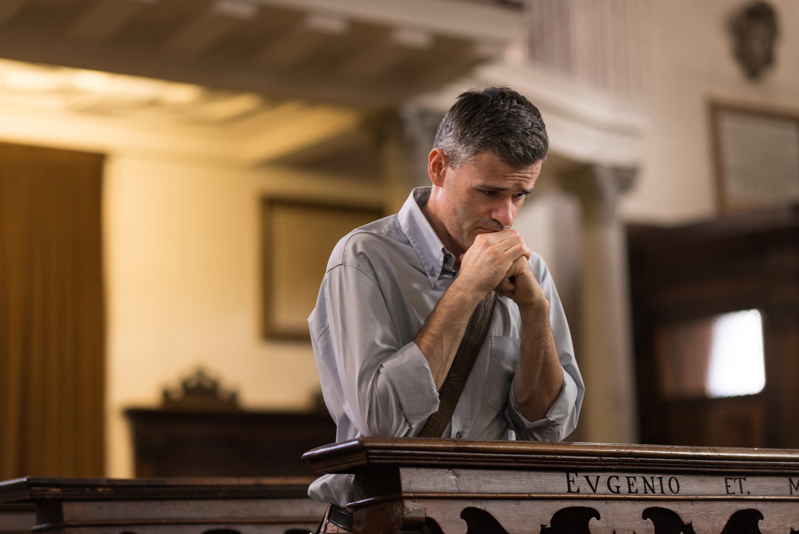Man praying in the Church | Ruah Woods Institute