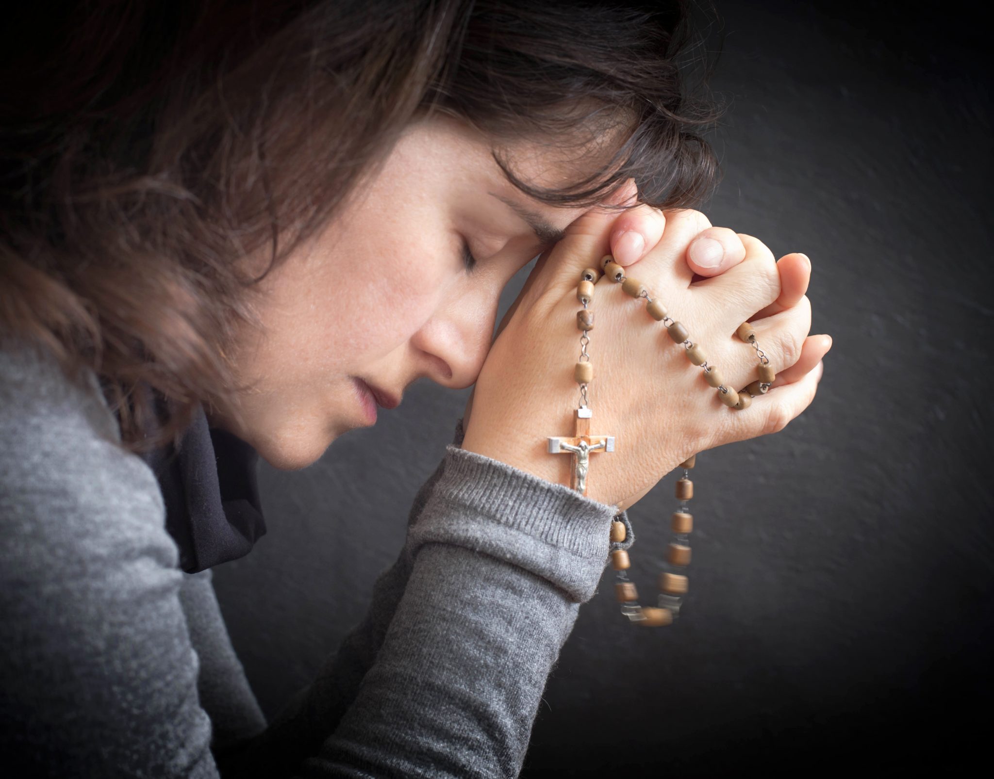 woman-praying-rosary | Ruah Woods Institute